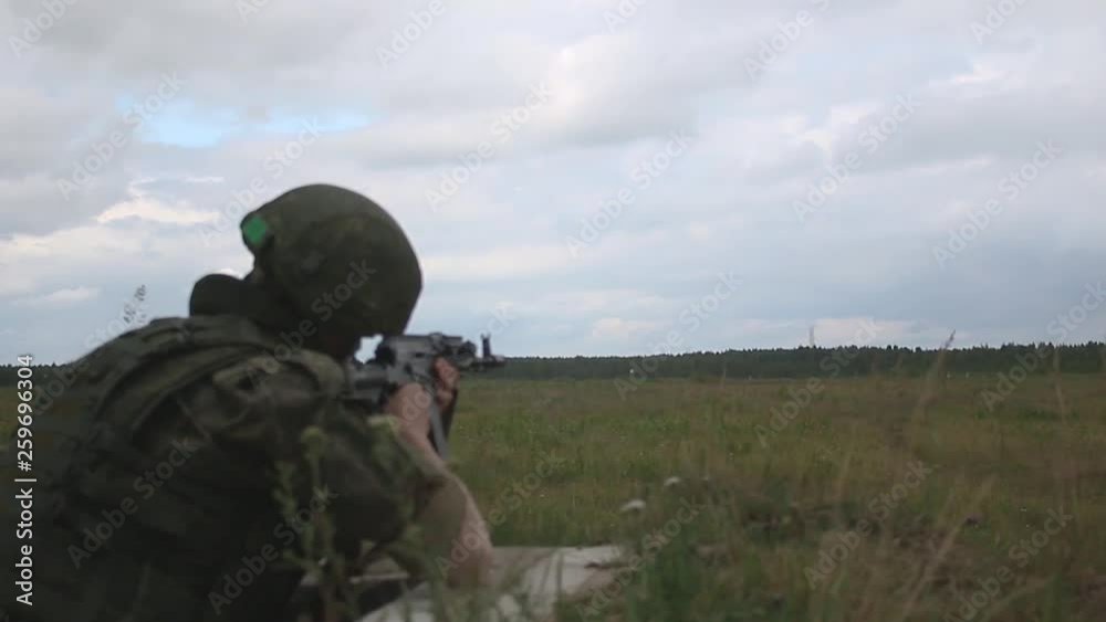 Vidéo Stock Russian soldier in armor and helmet firing a machine gun ...