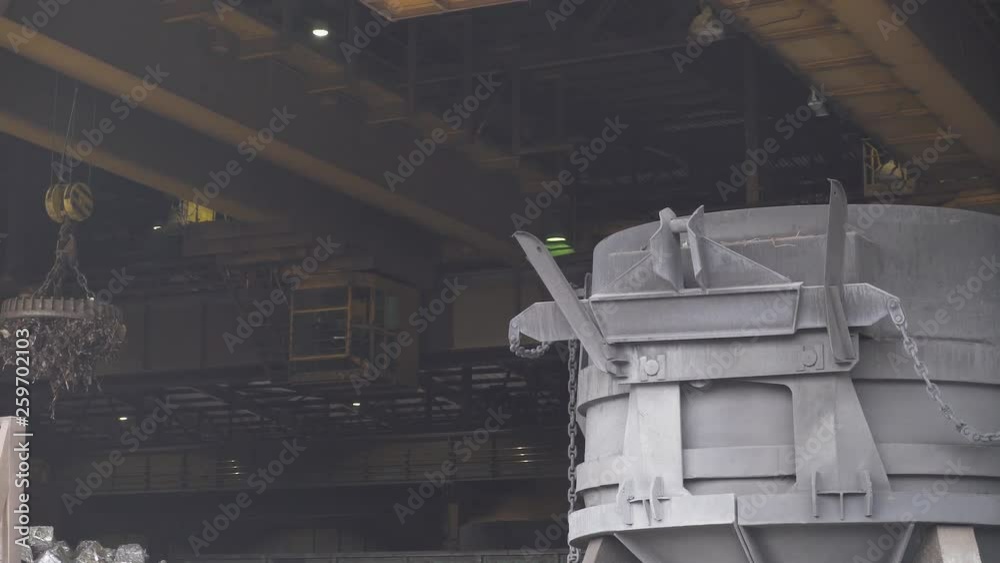 Steelmaking, the process of loading scrap metal into a tank for steel ...