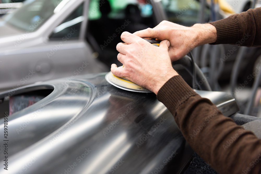 Foto Stock Professioneller Autolackierer schleift ein Autoteil mit der ...
