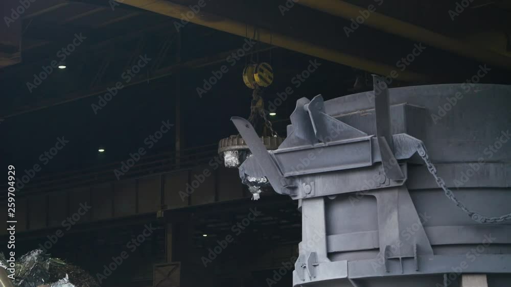 Steelmaking, the process of loading scrap metal into a tank for steel ...