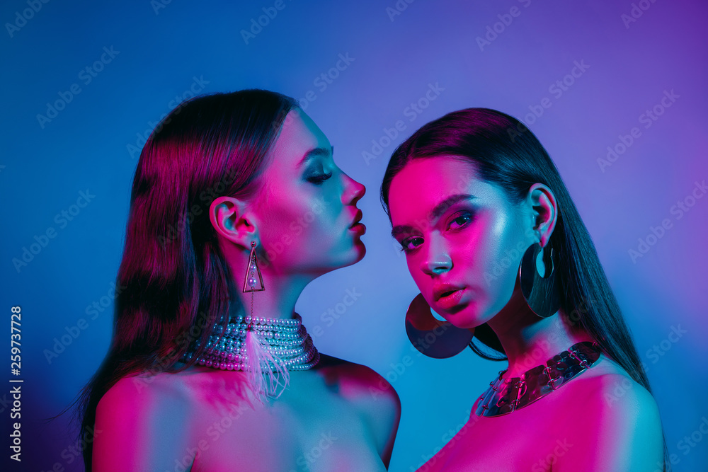 High fashion models in colorful bright neon lights posing at studio ...