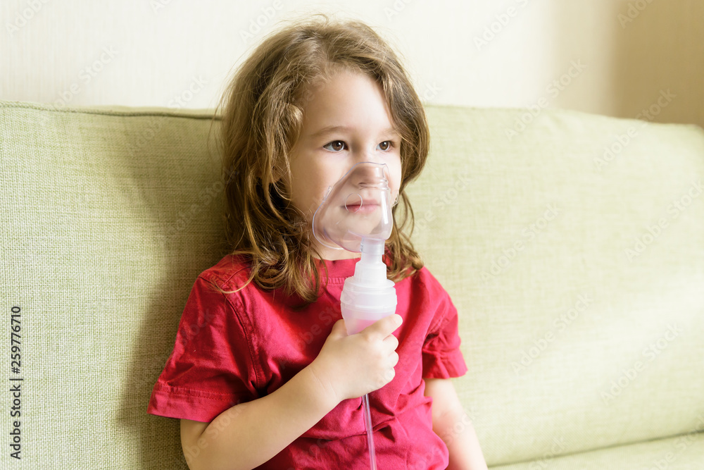 Little girl holds inhaler mask, kid breathes through nebulizer. Child ...