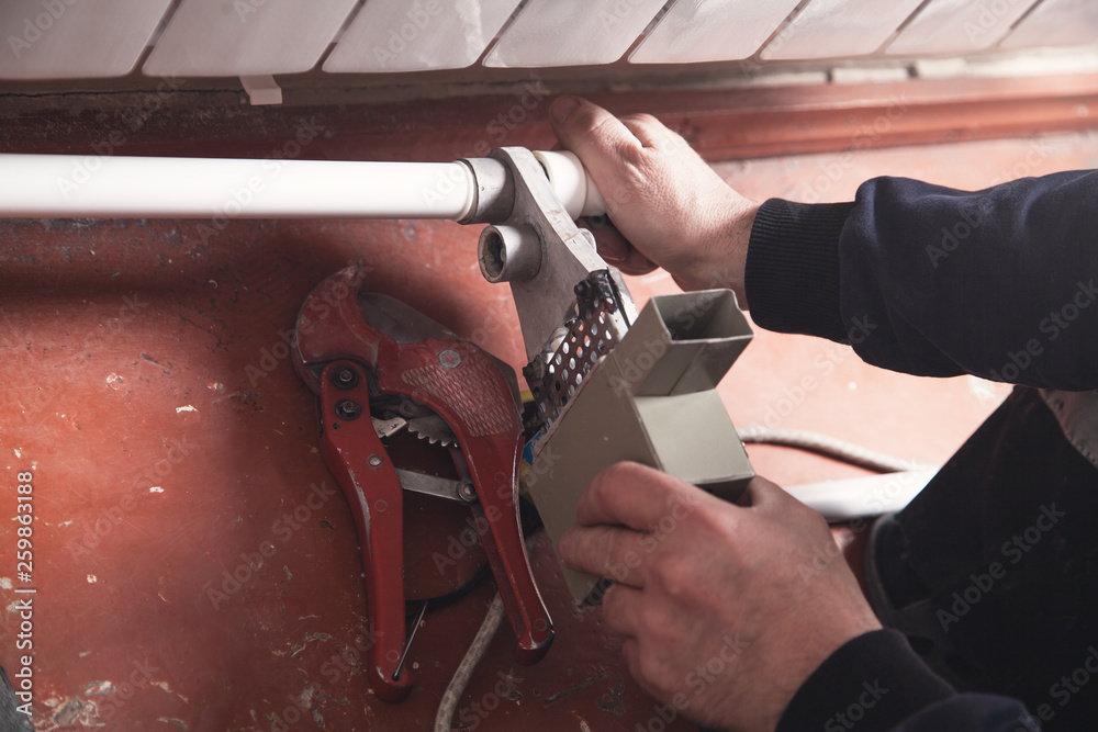 Worker connecting plastic pipe. Installing water heating radiator Stock ...