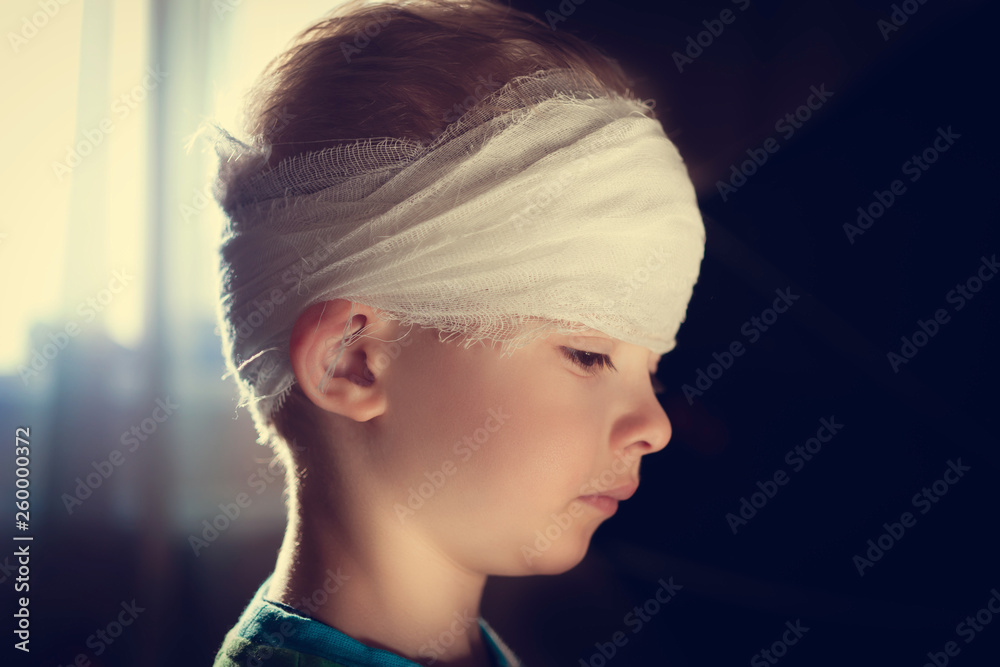 A child with a bandaged head. A pre-school boy with a head injury ...