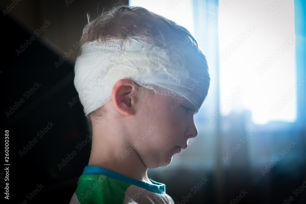A child with a bandaged head. A pre-school boy with a head injury ...