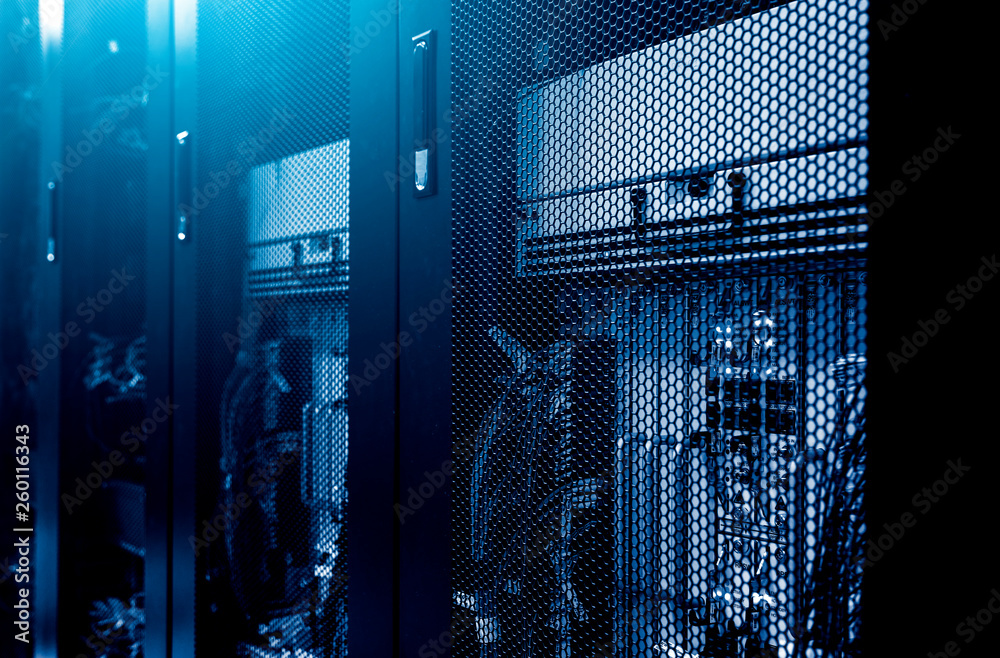 Modern server rack cluster under meshed door in big data centre with ...
