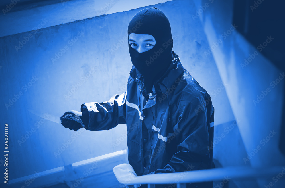 Bandit wearing a mask walking on stairs with a knife for the loot Stock ...