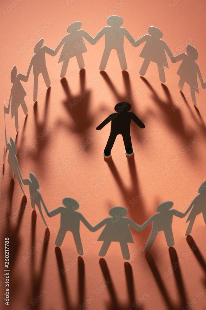 Paper human figure surrounded by circle of paper people holding hands ...