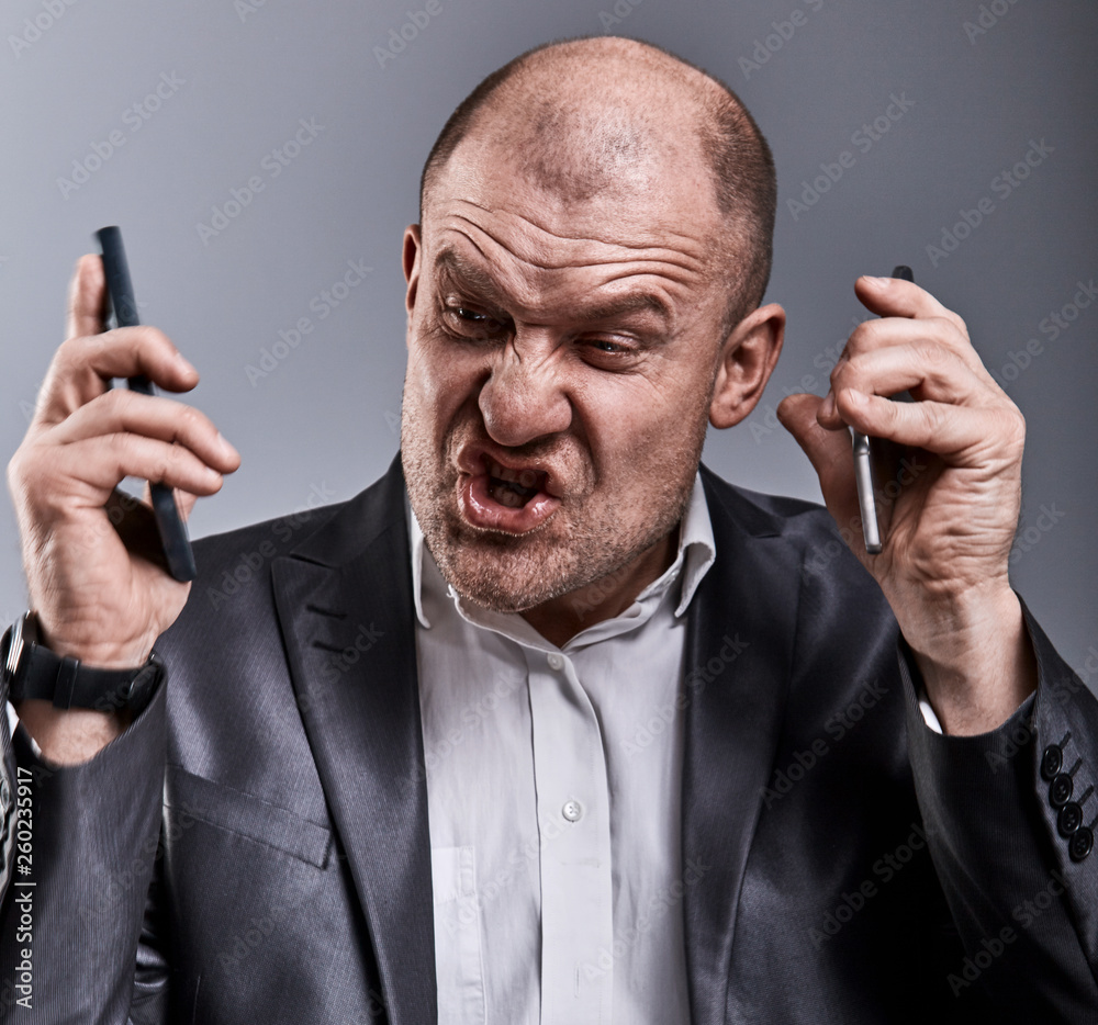 Turn nasty loud crying angry business man talking on two mobile phone ...