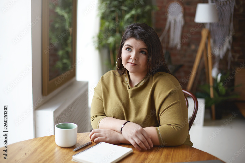 Pretty Girl With Chubby Cheeks And Curvy Body Doing Home Assignment Sitting Coworking Space With