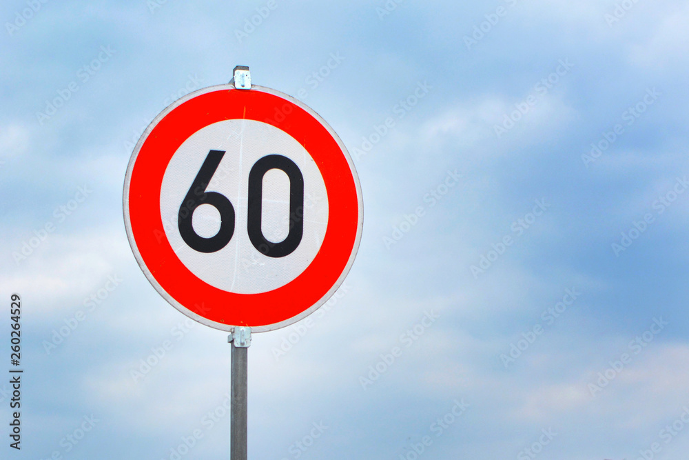 Red round 60km/h speed limit sign on highway in front of blue sky Stock ...