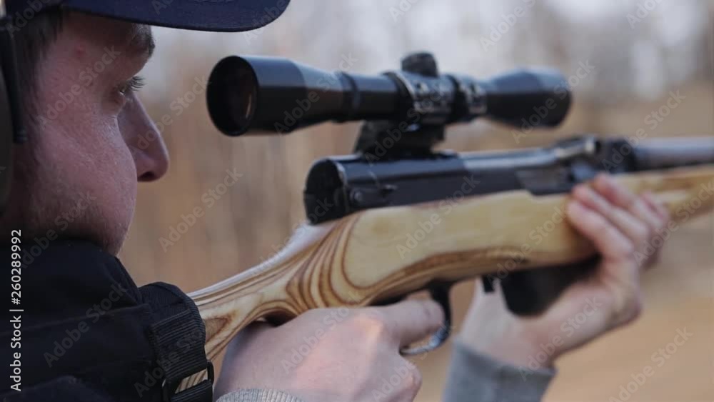 Super close-up of a man during a sniper rifle shot. The view from over ...