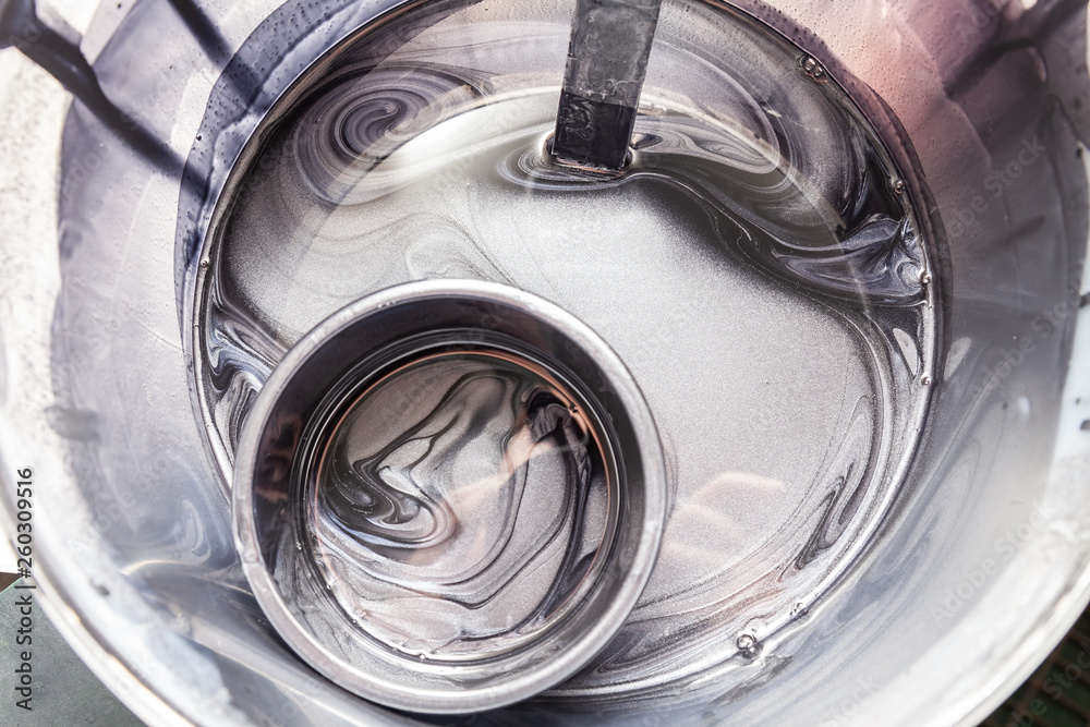 Close-up on the tank with silver black paint while mixing with spiral ...