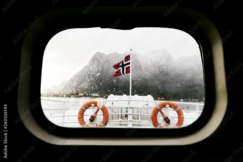 View through the bullseye window of a boat on to the norwegian flag and ...