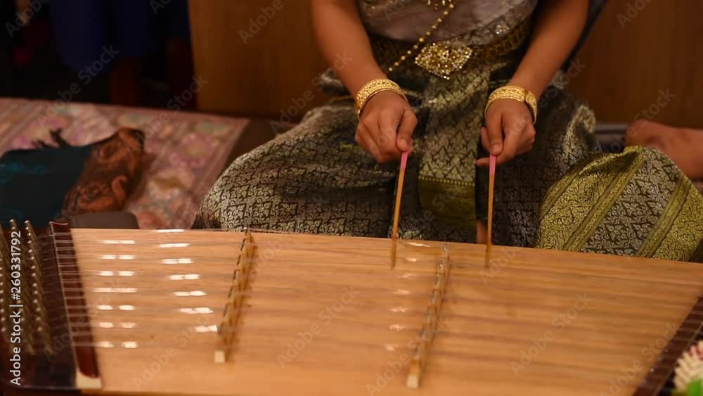 Close-up of Thai or chinese musician playing a traditional zither khim ...