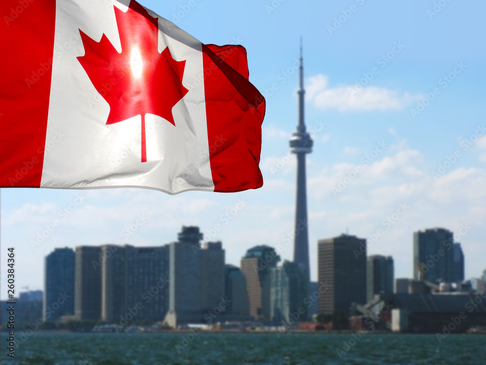 TORONTO, CANADA - Canadian flag is waving front of Toronto City view ...