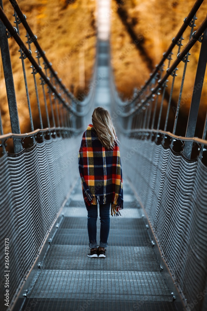 Young caucasian fashion model blonde girl standing on pedestrian bridge ...