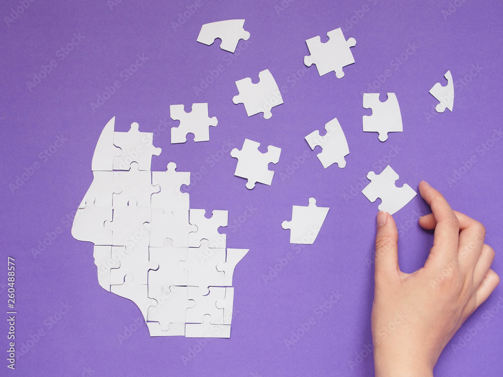 Female hand trying to connect pieces of white jigsaw puzzle as a human ...