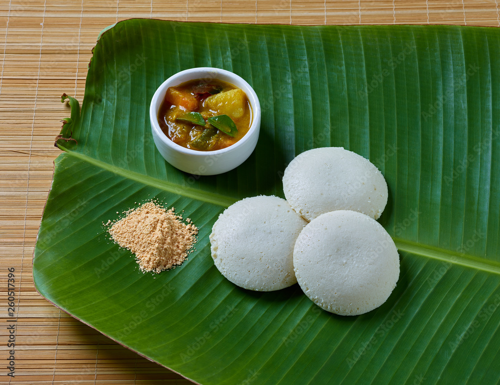 Kerala idli served on traditional banana leaf with sambar and chatni ...