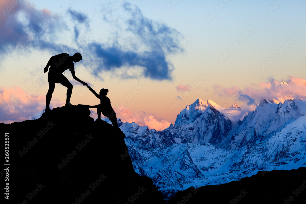 Teamwork concept, couple helping in sunset mountains, silhouette Stock ...