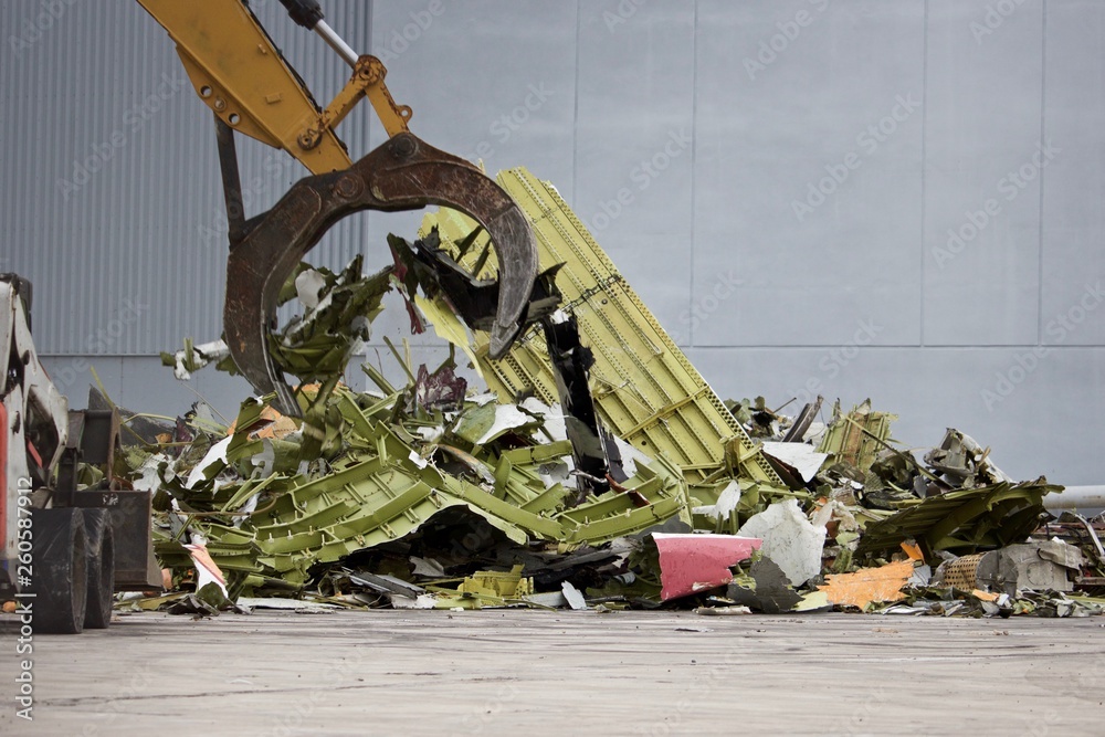 Aircraft fuselage section being reduced to scrap by a demolition ...