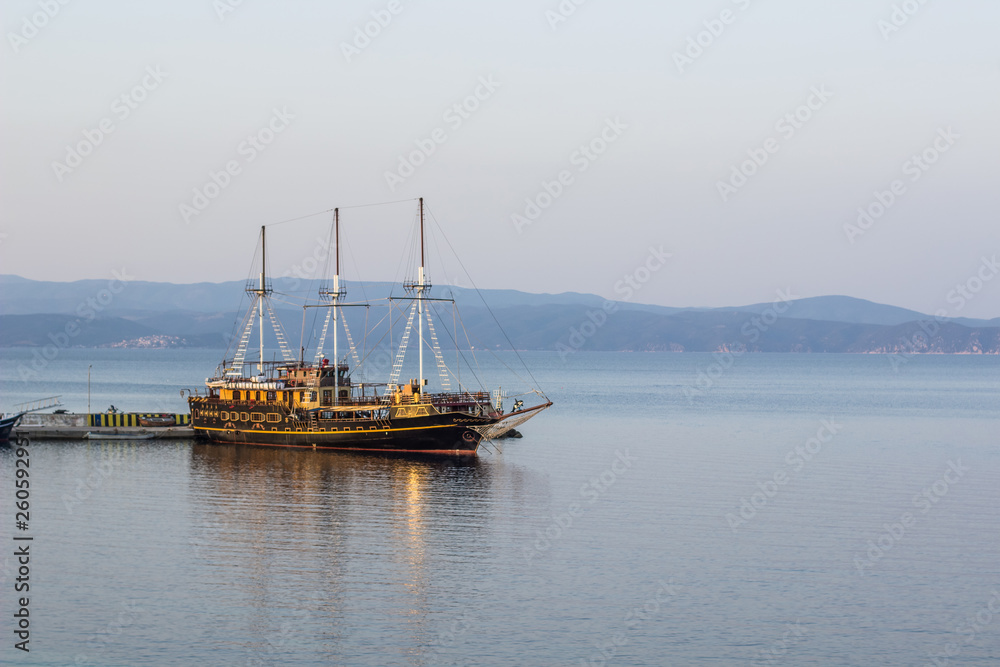 medieval vintage wooden sail ship anchored to pier harbor in outskirts ...