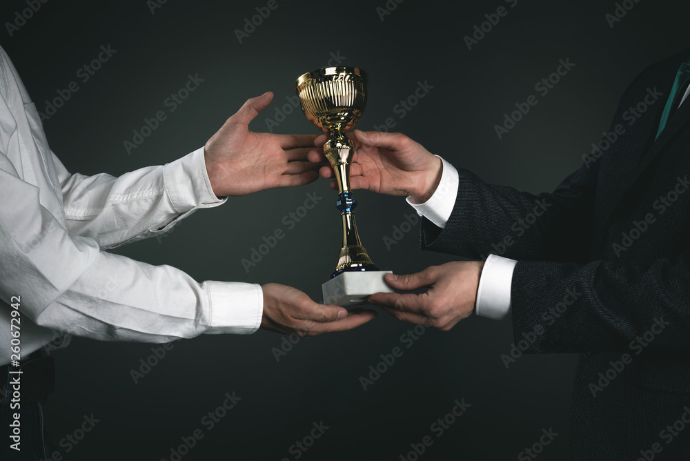 Award ceremony concept. Businessman is giving a golden cup award trophy ...