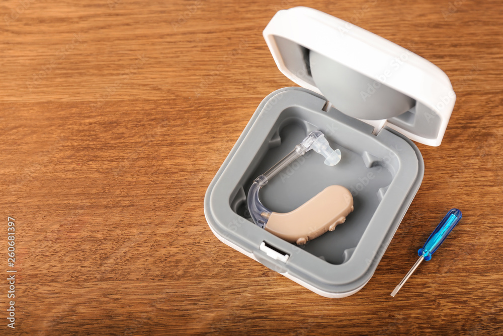 Box with hearing aid on wooden background Stock Photo | Adobe Stock