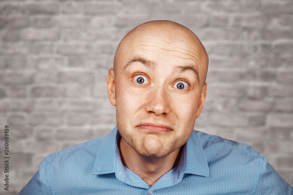 Portrait bald unsure man doesn't understand anything . guy in a blue ...