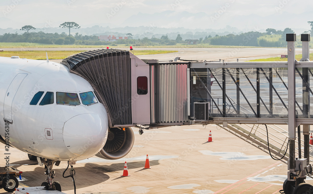 Jetway connected to the airplane for boarding passengers. Boarding ...