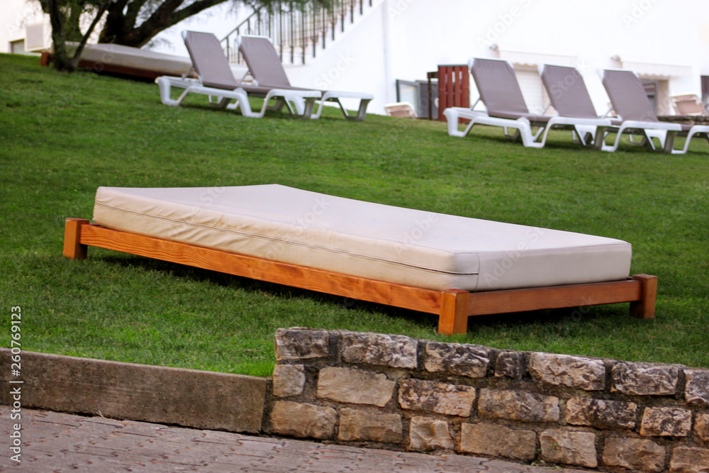 Comfortable white sun beds for sunbathing on grass, relax in tropical ...