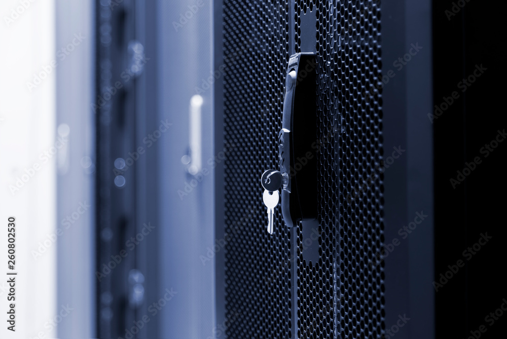 Close up meshed door with key in lock. Button in server room. Blur ...