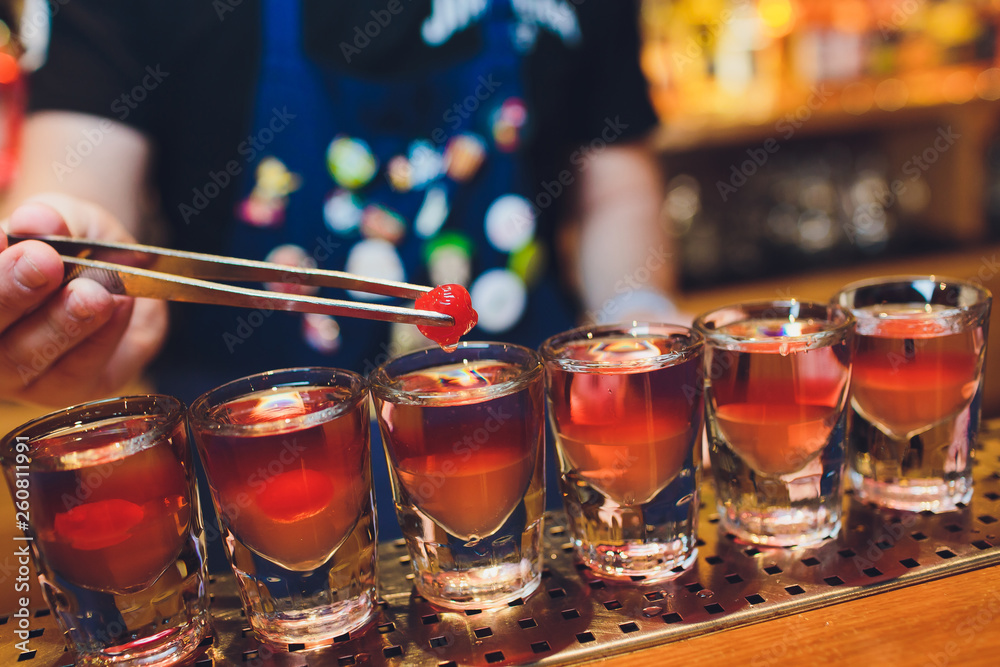 Bartender man making hot alcohol shots on the bar in the pub with a ...