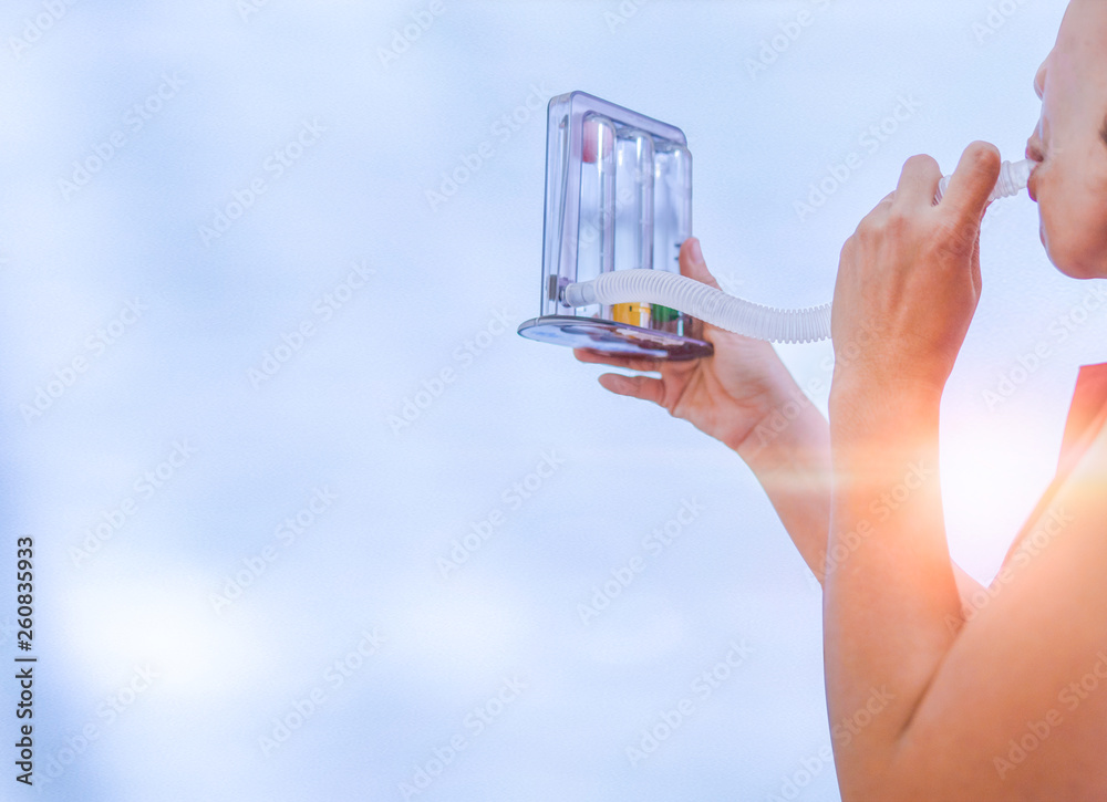Foto de woman holding triflow and deep breathing to improve lung ...