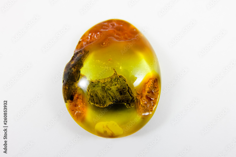 Multi-colored amber stone with yellow and red parts with the tree bark ...