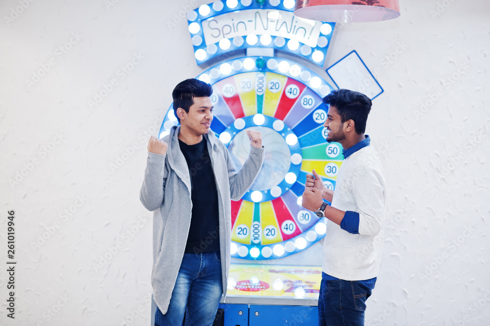 We are millionaires! Very excited two young asian guys against fortune ...