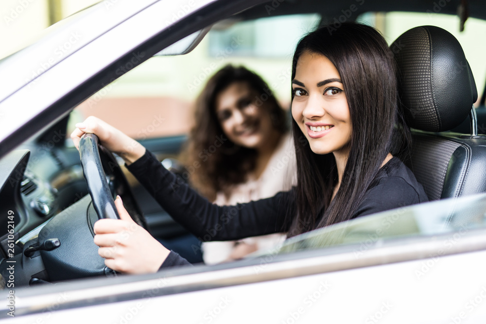 Two beautiful and pretty girls driving in car of their dream. Happy ...
