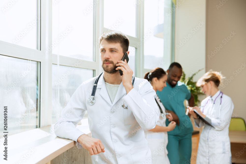 Healthcare people group. Professional caucasian male doctor with phone ...