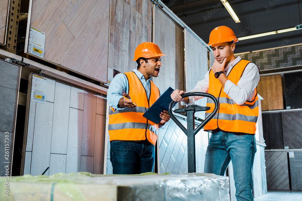 upset warehouse worker with pallet jack standing near angry yelling ...