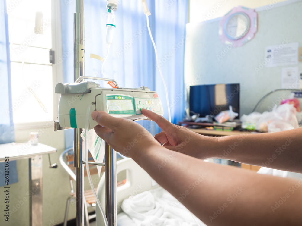 Close up nurse hand adjust infusion pump set iv fluid intravenous drop ...