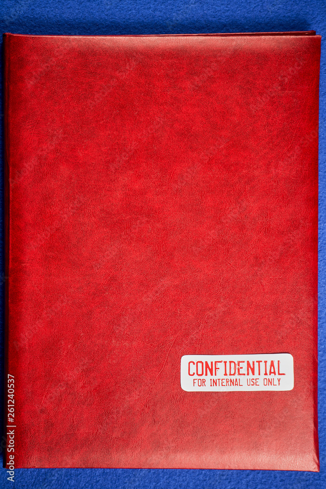 Red folder with the words Confidential for internal use only, on a blue ...