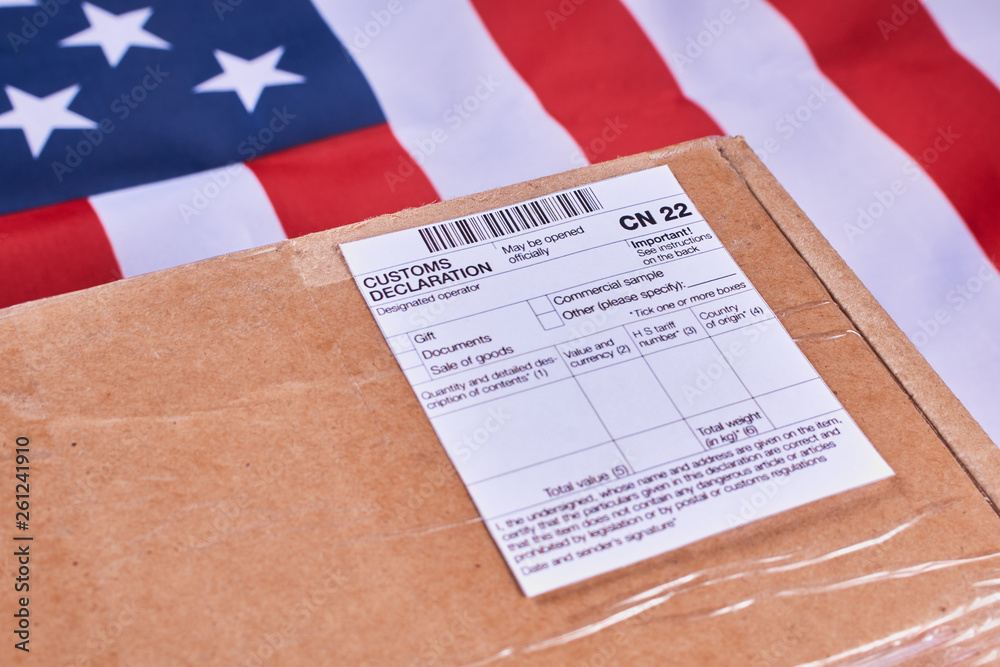 Parcel with Customs declaration form CN22 on American flag background ...