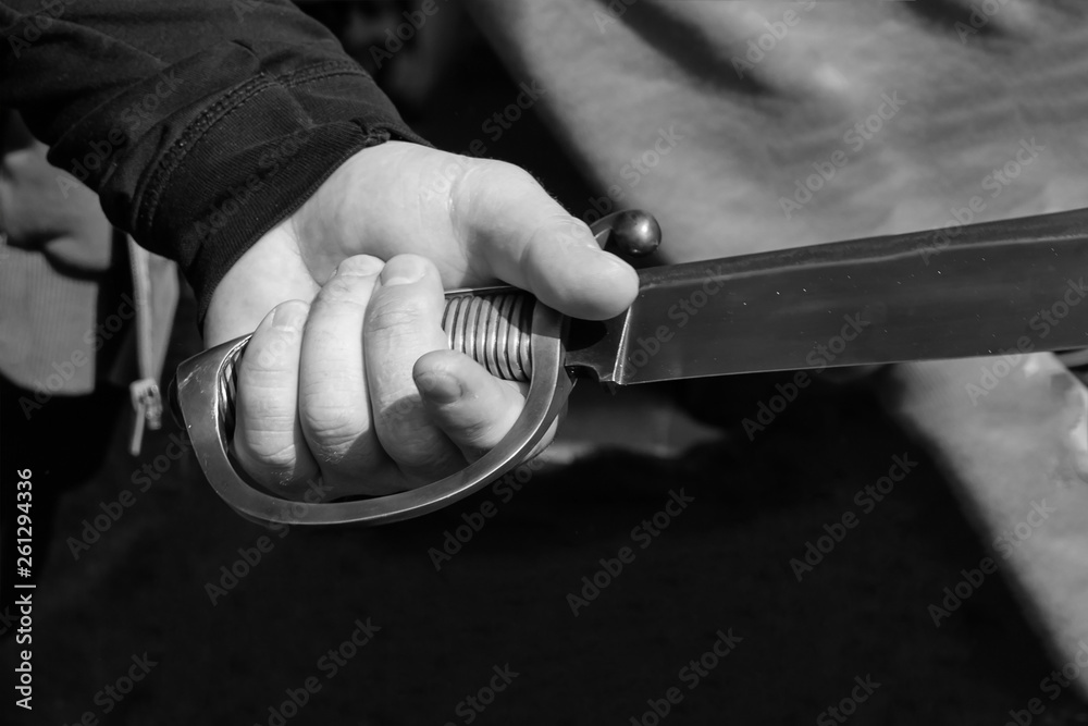 hand man ribbed handle wide knife hilt sword part of arms close-up ...