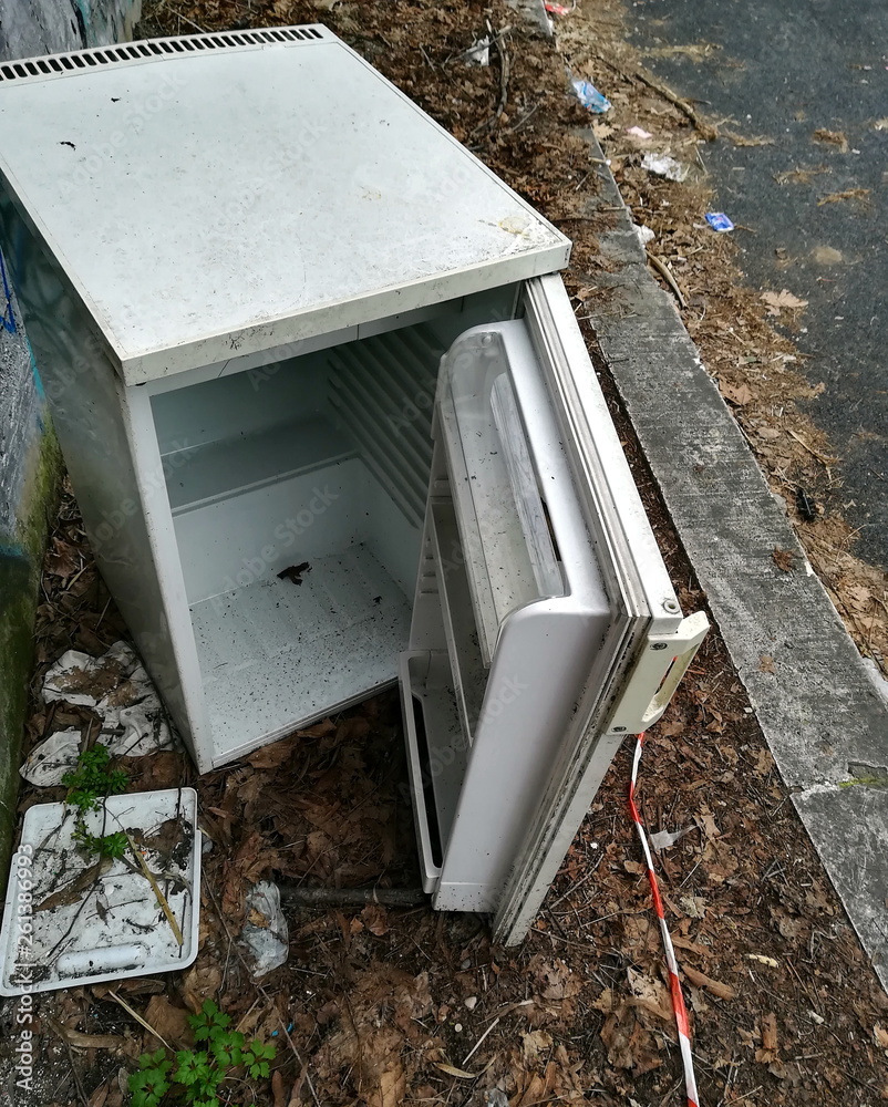 Broken small fridge abandoned in a city street, conceptual photo for ...