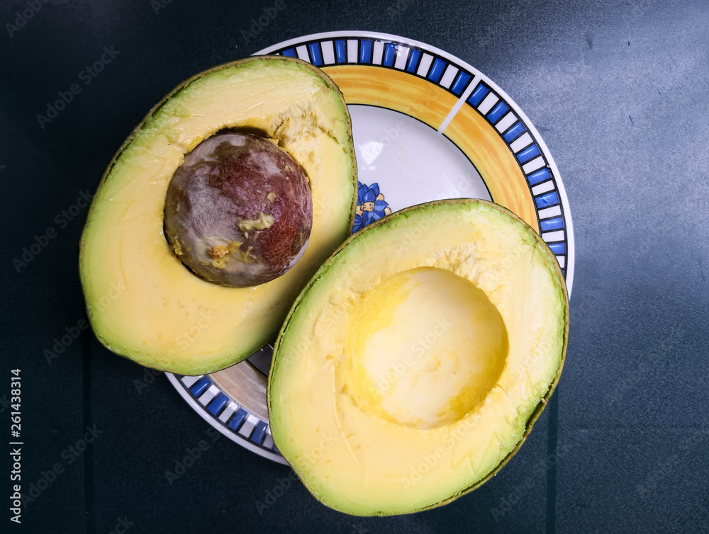 Delicious and ripe avocado, ready for consumption, opened in half with ...