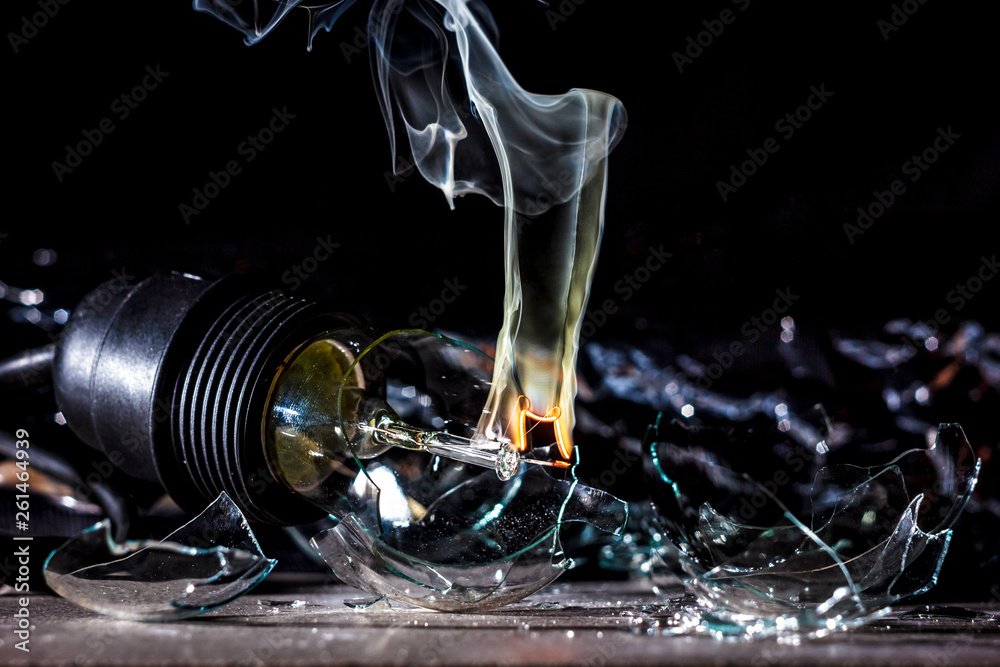 Amazing explosion of burning light bulb with splinters of broken glass ...