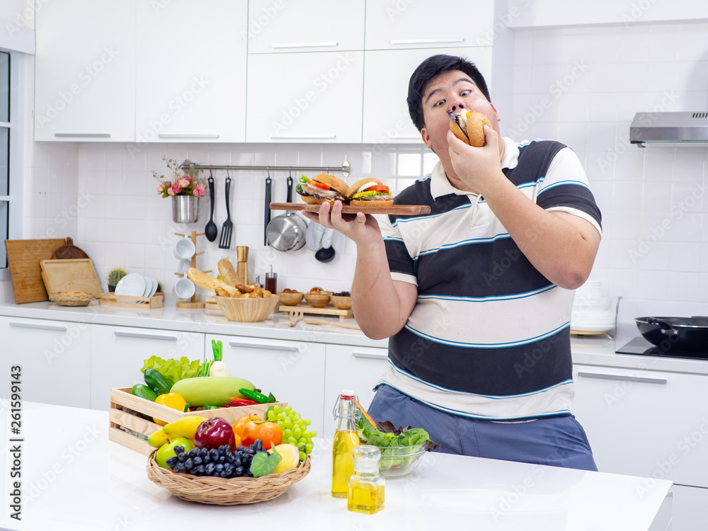 young Asia fat man happy when he eating unhealthy food or junk food ...