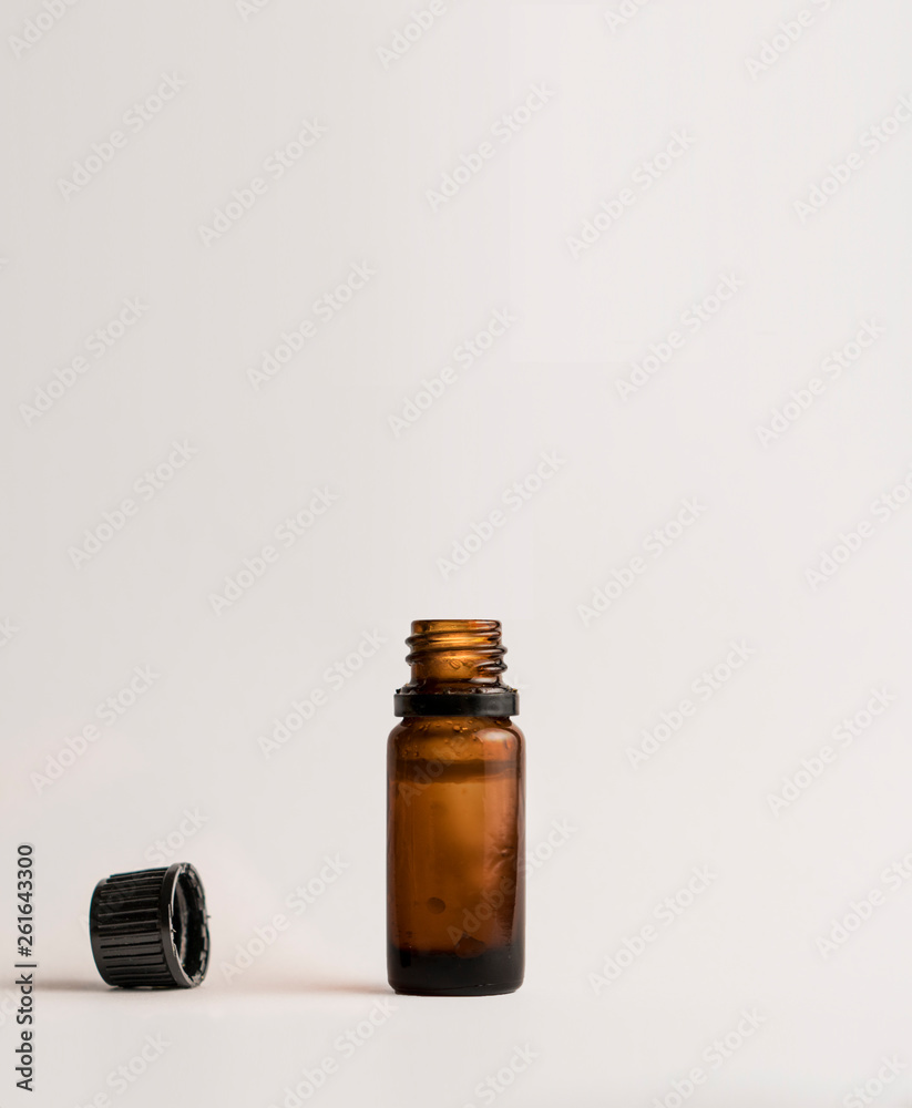 Small brown glass bottle, open with lid, isolated on white background ...