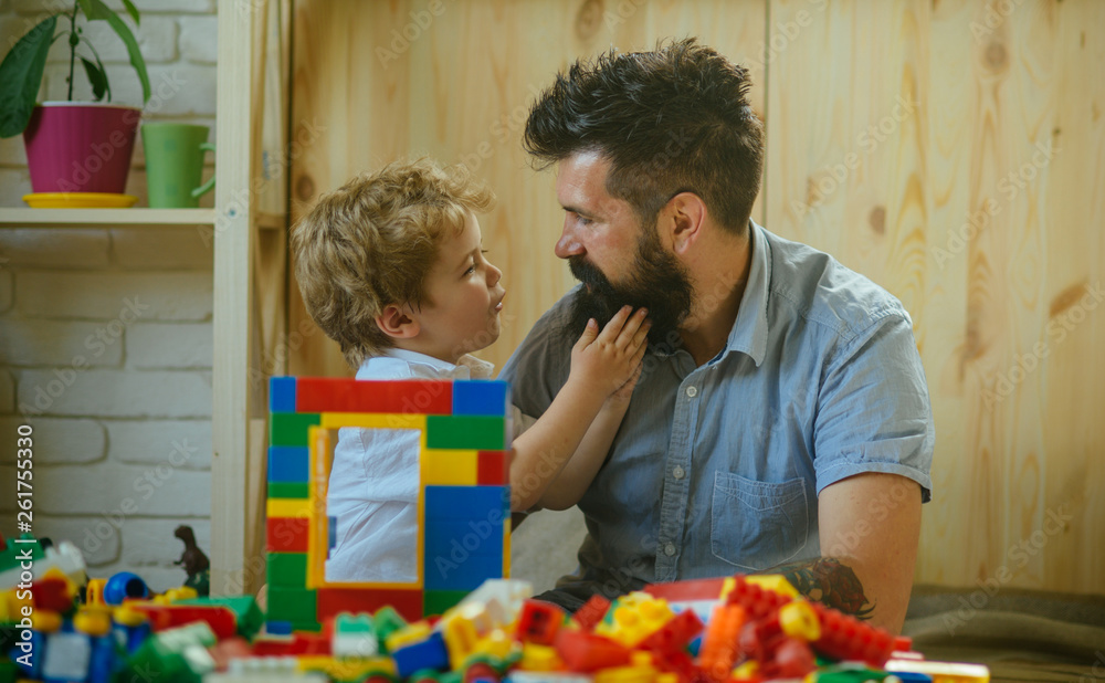 Father and son looks at each other. Little boy touches parent's berad ...