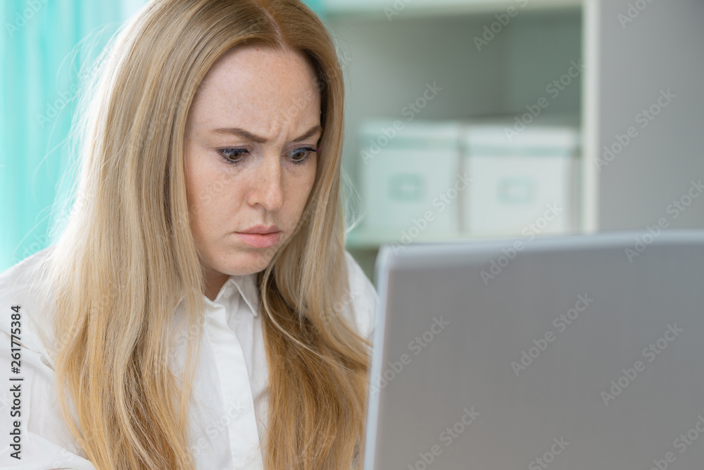 Portrait young shocked business woman sitting in front of laptop ...